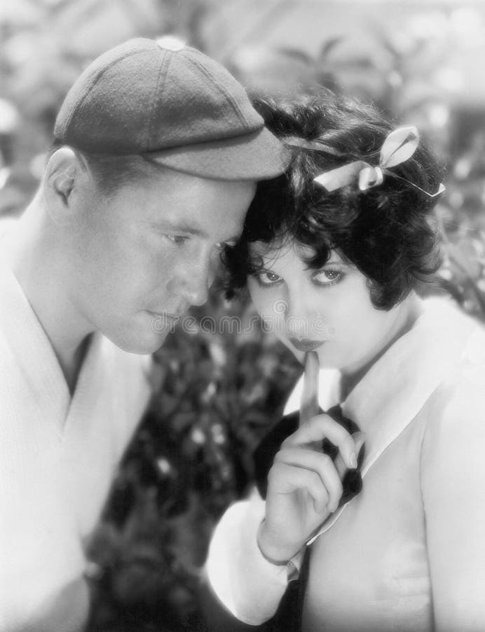 Man and Woman Standing Together with Her Looking Coy at the Camera ...