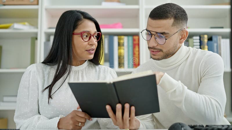 Man and Woman Students Reading Book Studying at University Classroom ... Man and Woman Students Reading Book Studying at University Classroom ...