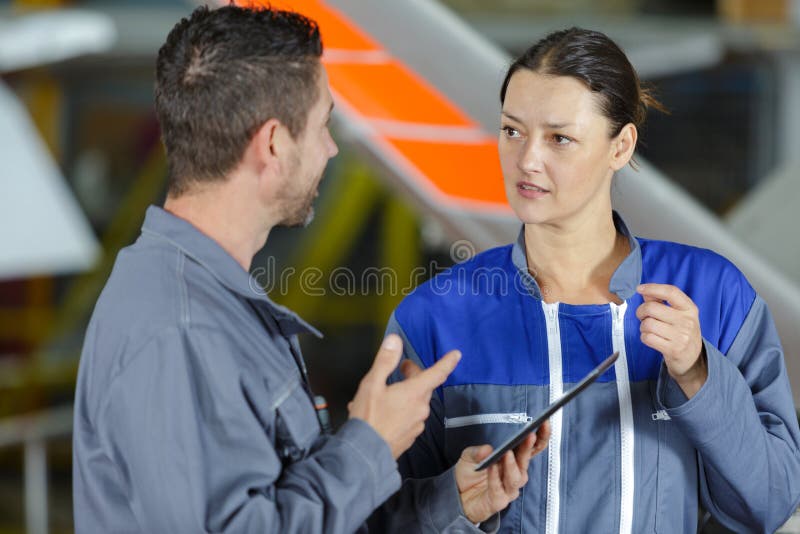 Man and Woman Talking about Work in Factory Stock Image - Image of ...