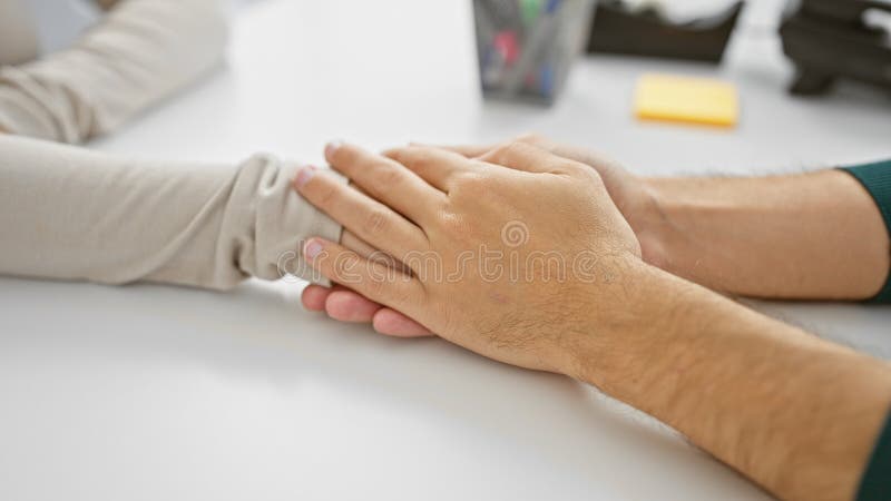 A Man and Woman Teaming Up in a Bright Office Touching Hands in a ...