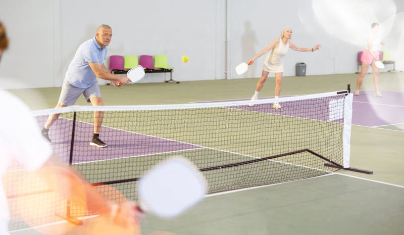 Man And Woman Training To Play Pickleball Tennis On The Pickleball Cour