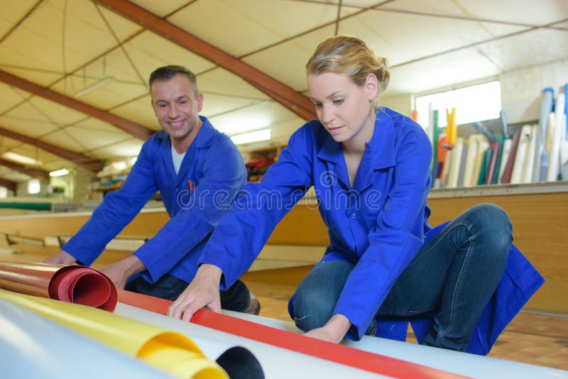 Man and Woman Unrolling Material Stock Photo - Image of warehouse ...