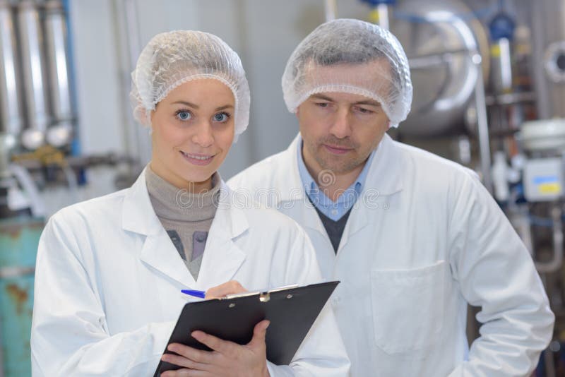 Man and Woman Wearing Hair Nets Making Notes on Clipboard Stock Image ...