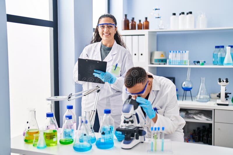 Man and Woman Wearing Scientist Uniform Using Microscope Write on ...