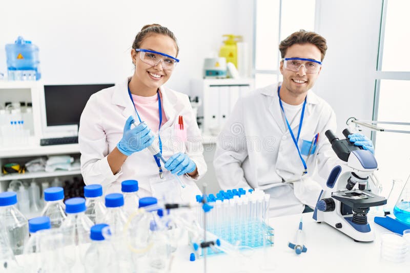 Man and Woman Wearing Scientist Uniform Using Pipette and Microscope ...