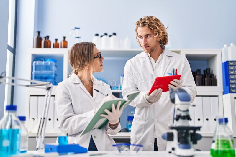 Man and Woman Wearing Scientist Uniform Writing on Notebook Using ...