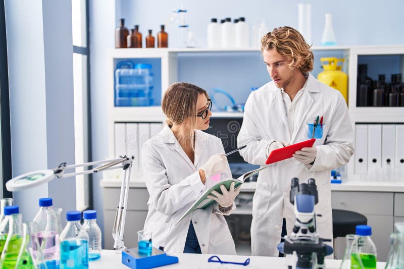 Man and Woman Wearing Scientist Uniform Writing on Notebook Using ...