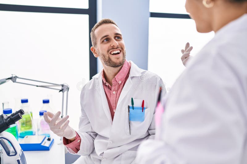Man and Woman Wearing Scientists Uniform Speaking at Laboratory Stock ...