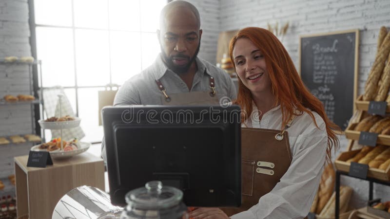 Man and Woman Working Together in a Bakery, Looking at a Computer ...