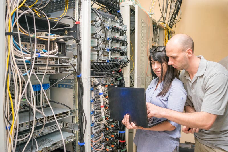 Man and Woman Set Up Network Equipment in the Server Room. Teamwork ...