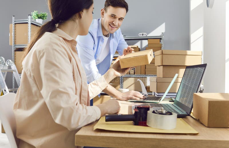 Man and Woman Working Together with Laptop in Warehouse with Packages Stock Photo - Image of ...
