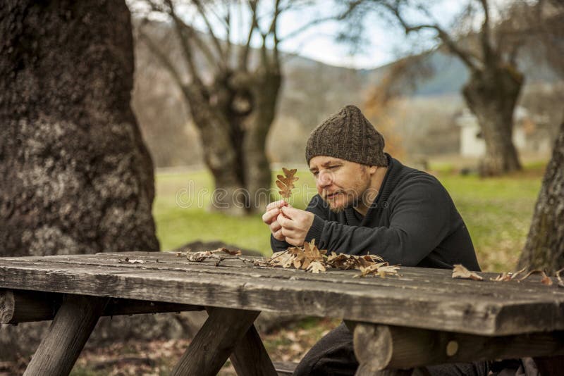 Man with Wool Hat Sitting on the Bench in the Park in Autumn Background ...