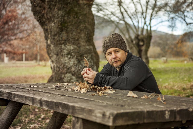 Man with Wool Hat Sitting on the Bench in the Park in Autumn Background ...