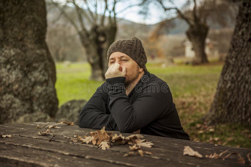 Man with Wool Hat Sitting on the Bench in the Park in Autumn Background ...