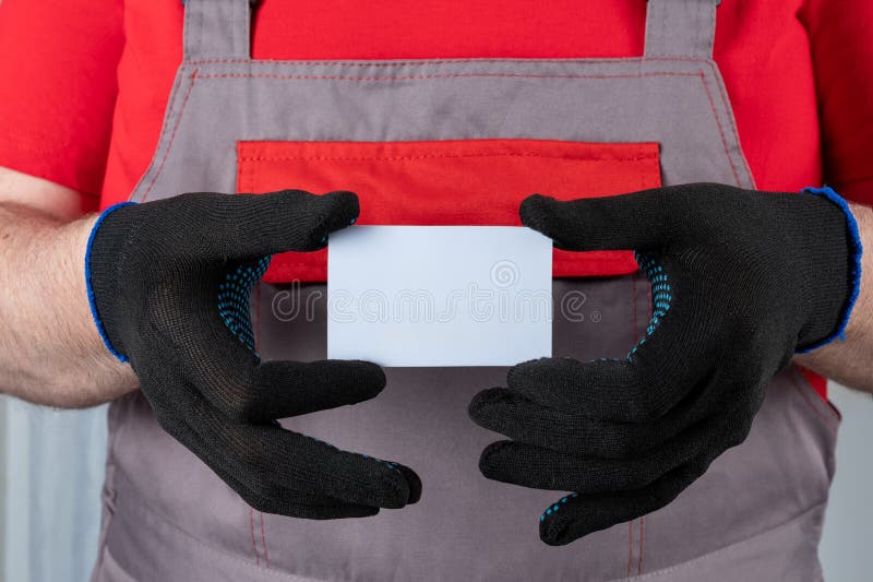 A Man in Work Clothes and Gloves Holds a Plastic Card in His Hands ...