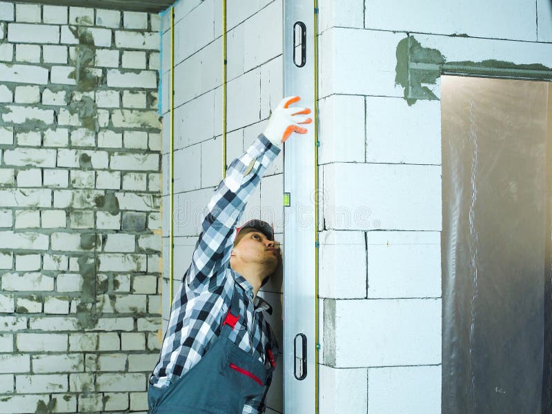 Man in Work Wear Spreading Plaster on Block Wall with Construction ...