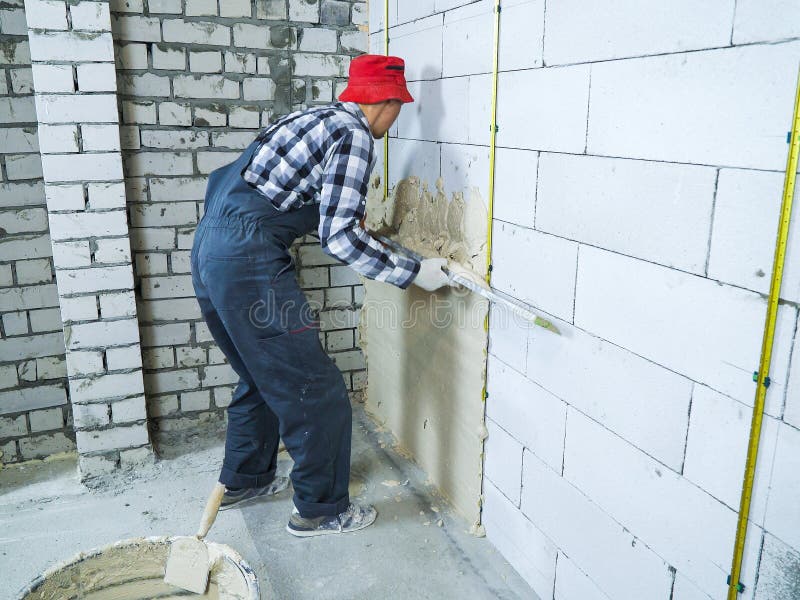 Man in Work Wear Spreading Plaster on Block Wall with Construction ...
