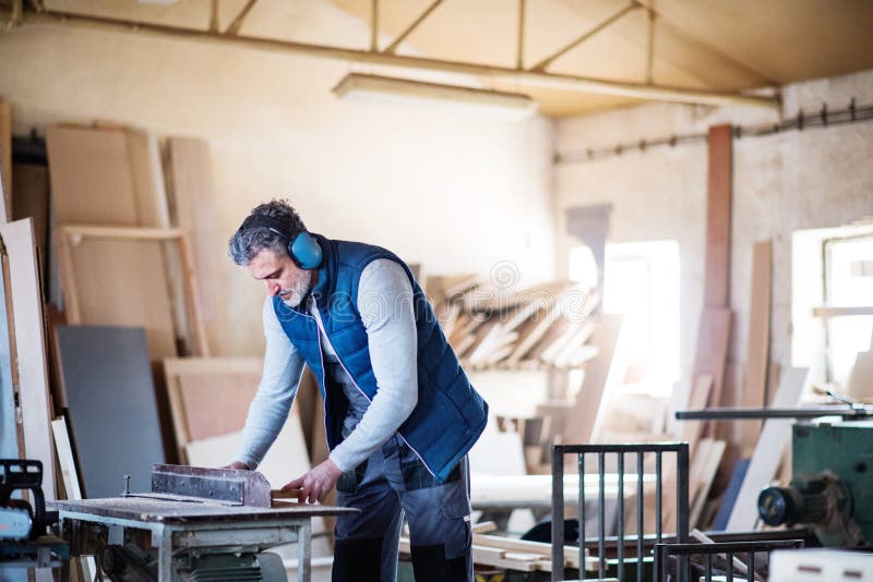 A Man Worker in the Carpentry Workshop, Working with Wood. Stock Photo ...