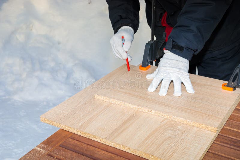 A Man, a Worker Draws with a Pencil on a Chipboard Board. Stock Photo ...