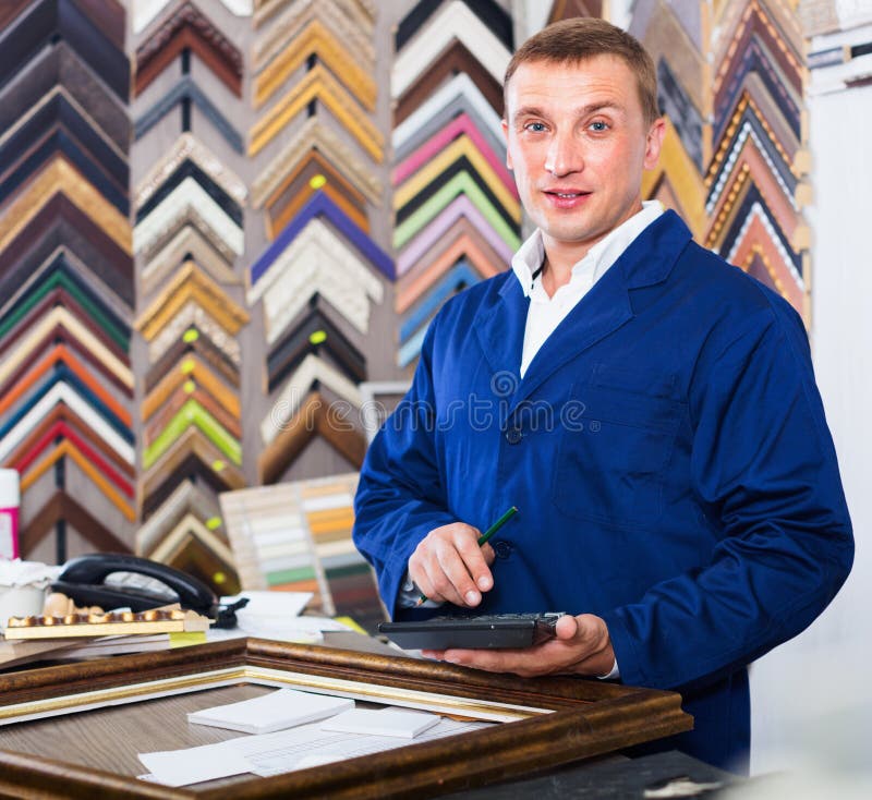 Man Worker Holding Picture Frame Details on Counter Stock Image - Image ...
