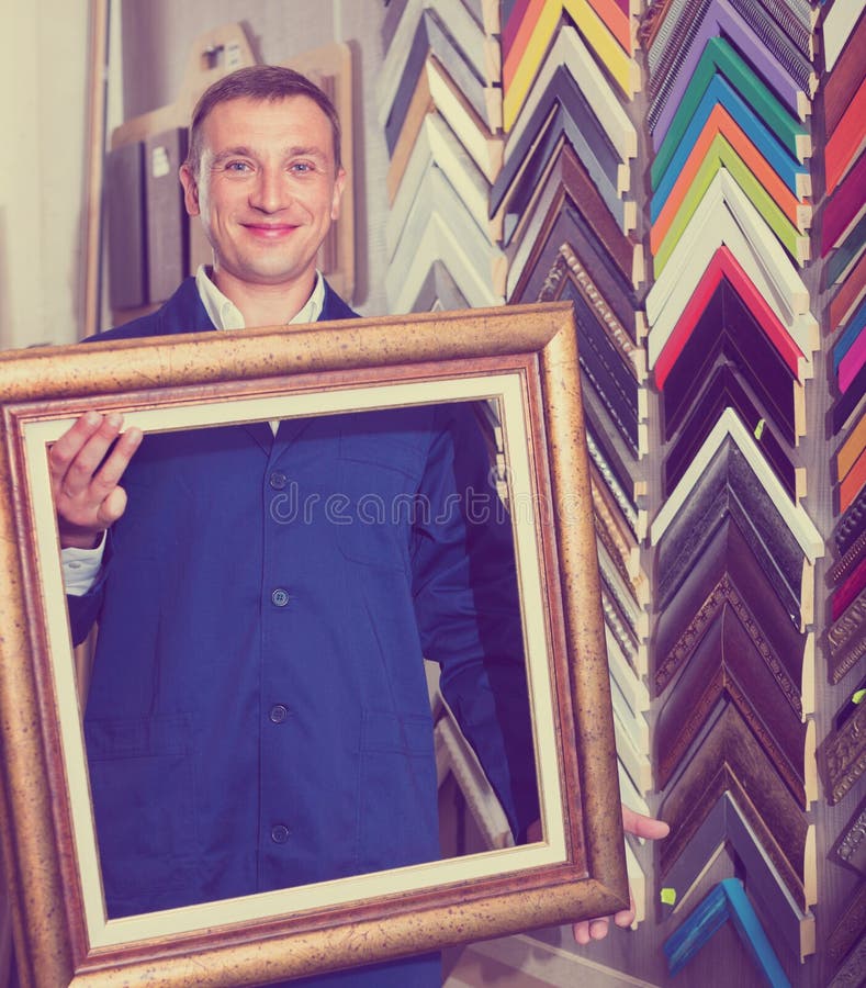 Man Worker Holding Picture Frame Details on Counter Stock Image - Image ...