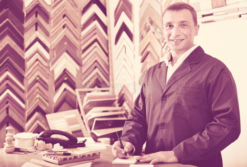 Man Worker Holding Picture Frame Details on Counter Stock Image - Image ...