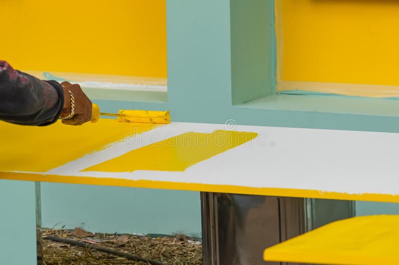 Man Worker Paints a Surface with a Roller with Yellow Paint Stock Photo ...