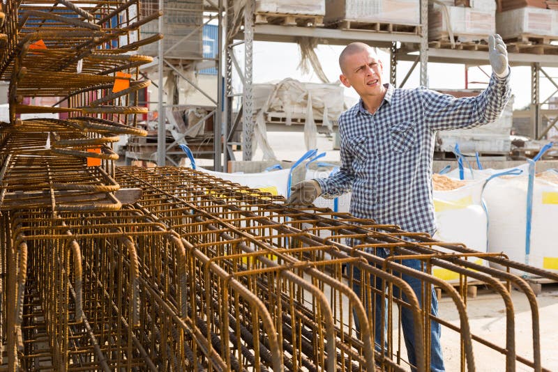 Man Worker with Reinforcing Steel Bars during Work in Warehouse Stock ...