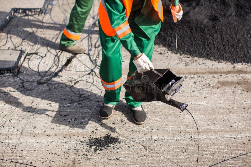 The Man Working Asphalt Pouring Tar for Road Repair. Stock Photo ...
