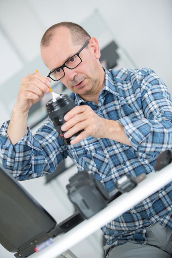 Man working on camera lens stock photo. Image of hand - 118387400