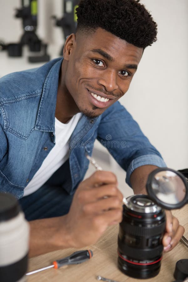 Man working on camera lens stock image. Image of component - 205719463