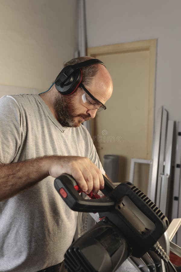 Man Working in Carpentry, Operating an Electric Cutting Machine. he ...