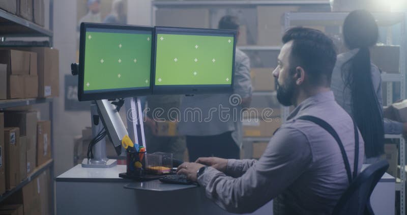 Man Working at a Computer in a Distribution Center Stock Photo - Image ...