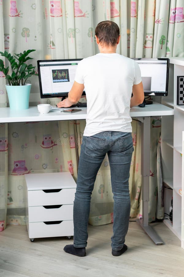 Man Working on Computer at Standing Desk at Home Office Stock Photo ...