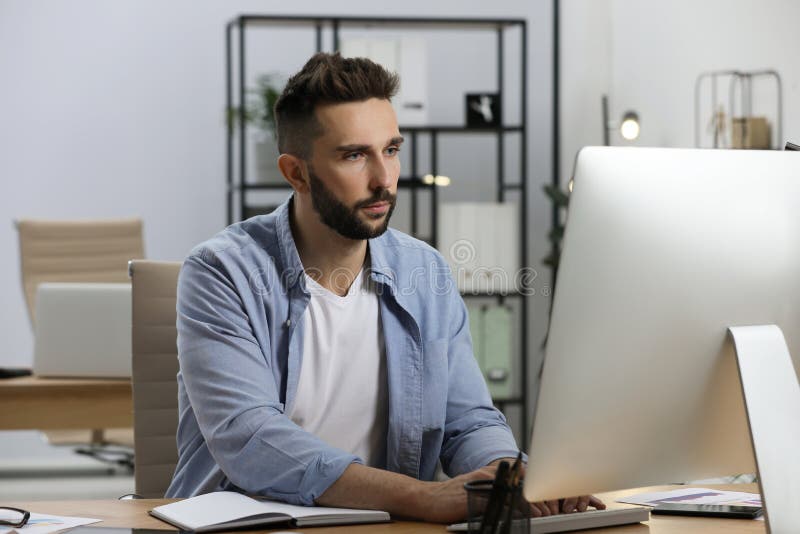 Man Working on Computer at Table in Office Stock Image - Image of ...