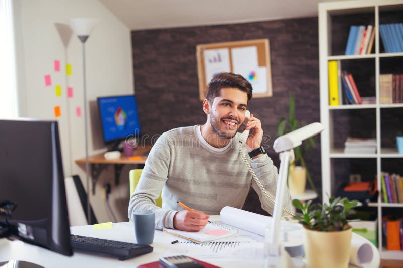 Man Working on Computer Talking on Landline Phone Stock Image - Image ...