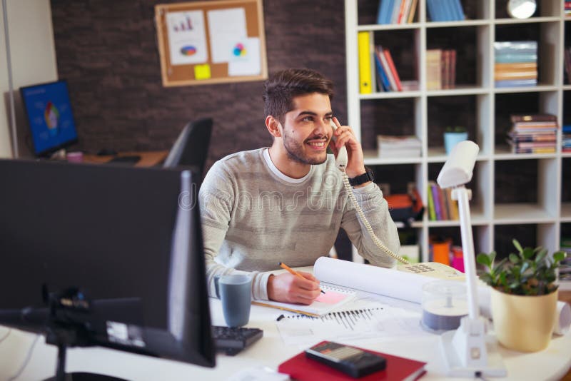 Man Working on Computer Talking on Landline Phone Stock Photo - Image ...
