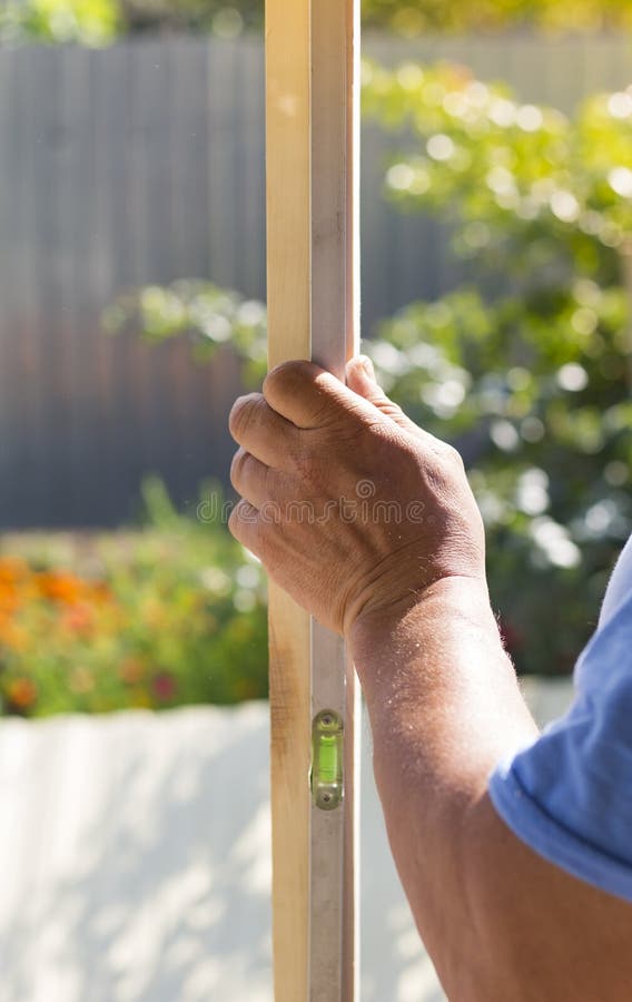 A Man Holds a Building Level Stock Photo - Image of male, construction ...