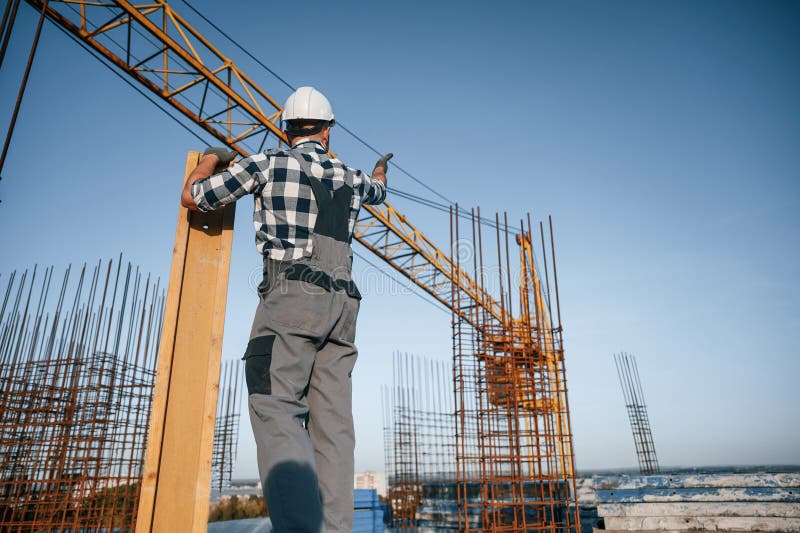 Man is Working on the Construction Site at Daytime. with Wooden Plank ...