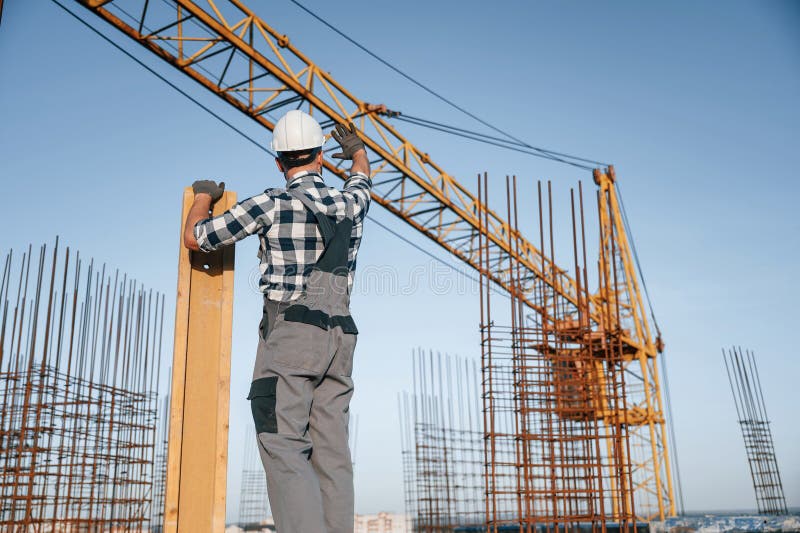Man is Working on the Construction Site at Daytime. with Wooden Plank ...