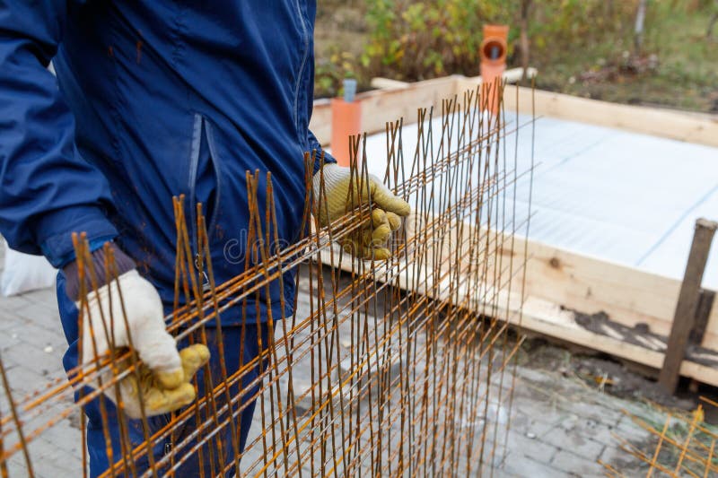 A Man is Working on a Construction Site, Holding a Piece of Wire ...
