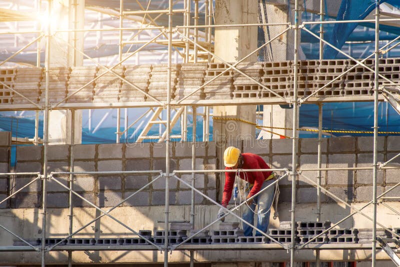 Man Working on Construction Site with Scaffold and Building with Sun ...