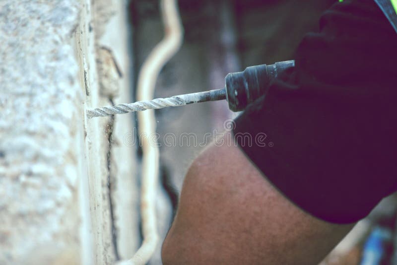 Man Working a Construction Site Tightening a Rock with a Power Drill ...