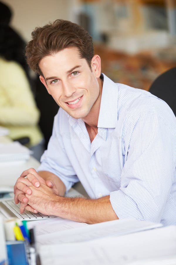 Man Working at Desk in Busy Creative Office Stock Image - Image of ...