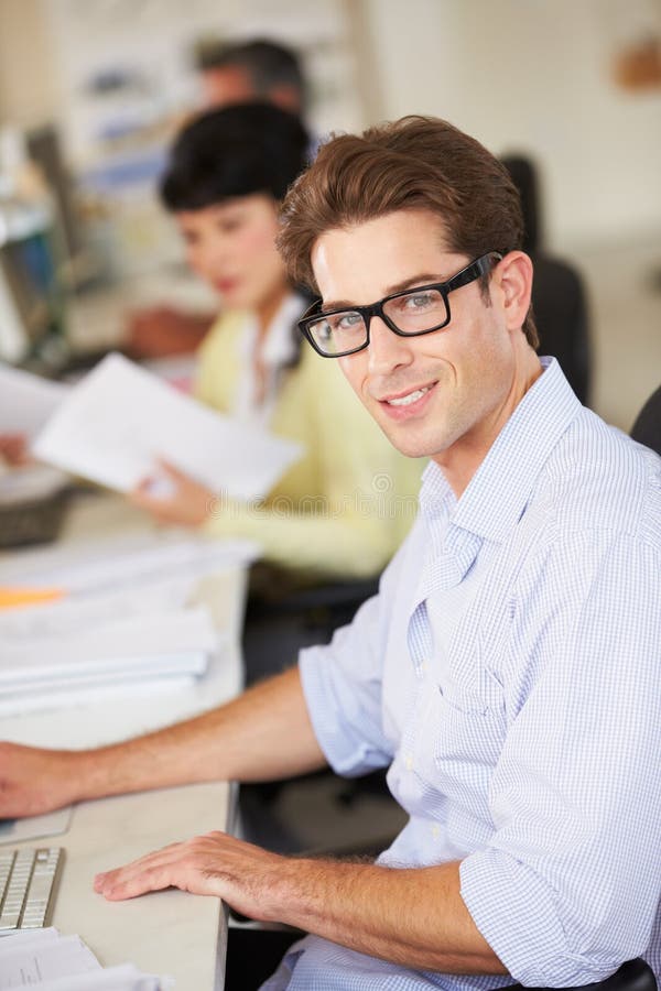 Man Working at Desk in Busy Creative Office Stock Image - Image of ...