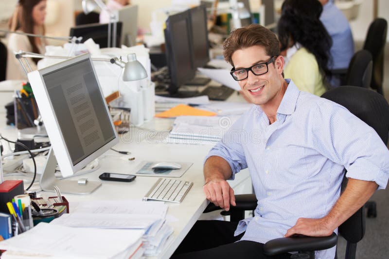 Man Working at Desk in Busy Creative Office Stock Image - Image of ...