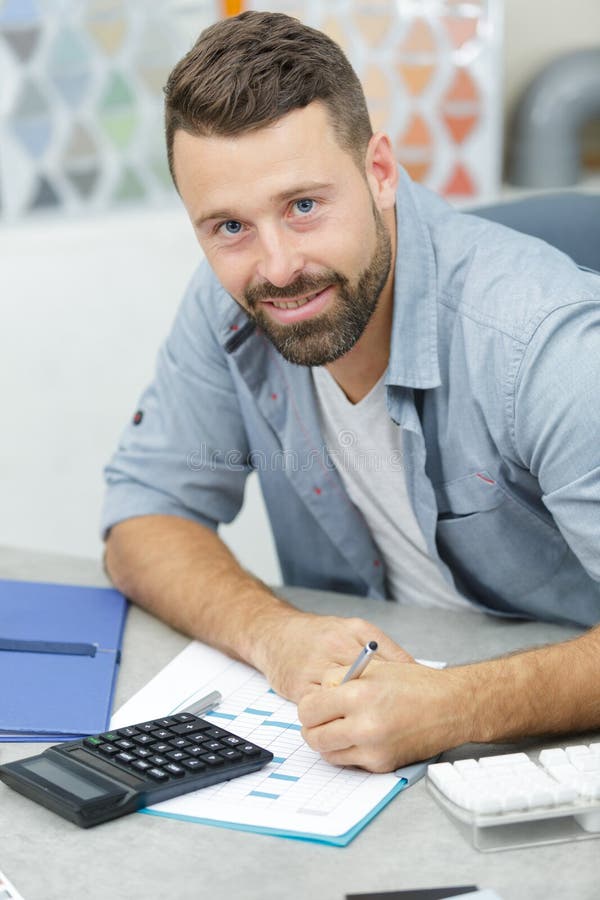 Man Working on Drawing and Engineering Calculator in Office Stock Photo ...