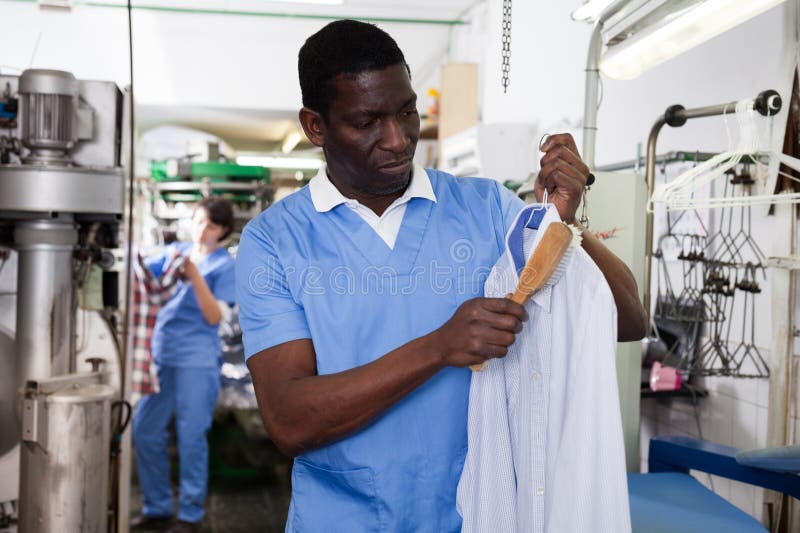 Man working in dry cleaner stock photo. Image of adult - 281360324