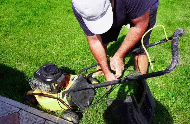 The Man is Working in the Garden. Mowing Grass with a Lawn Mower Stock ...