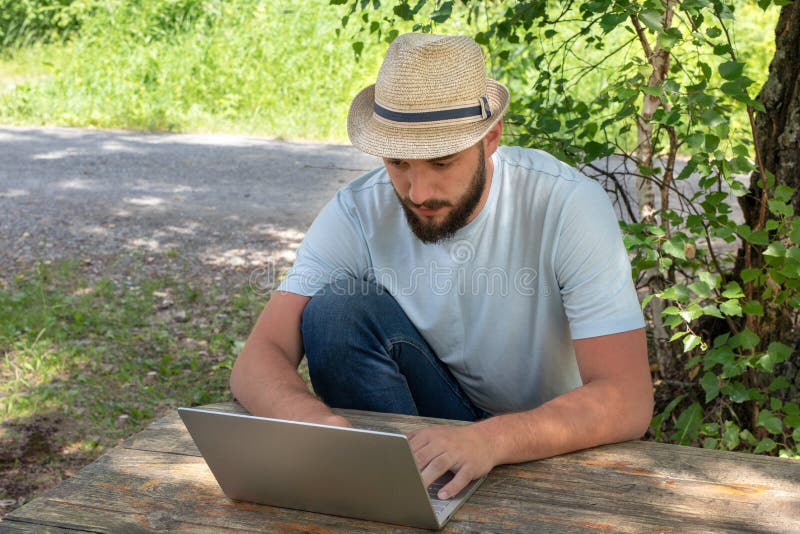 Man is Working Hard at a Computer in Nature. the Concept of Remote Work ...